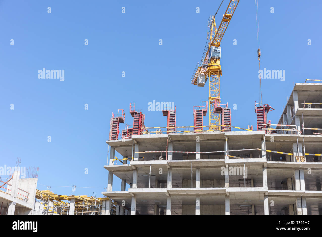 multi-level concrete building under construction with tower crane ...