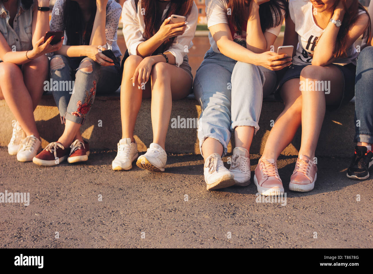 Crop photo of group of young happy tan girls real friends using mobile ...