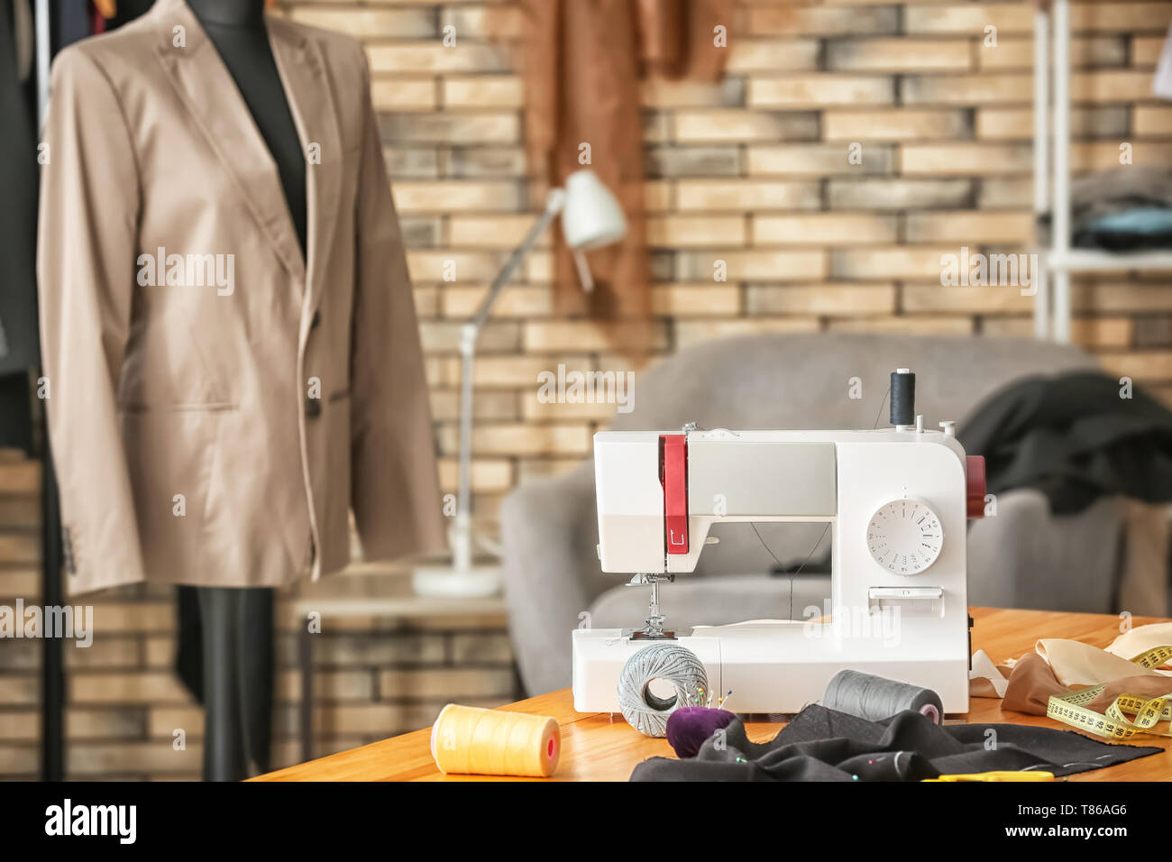 Tailor's workplace with sewing machine and mannequin in atelier Stock ...