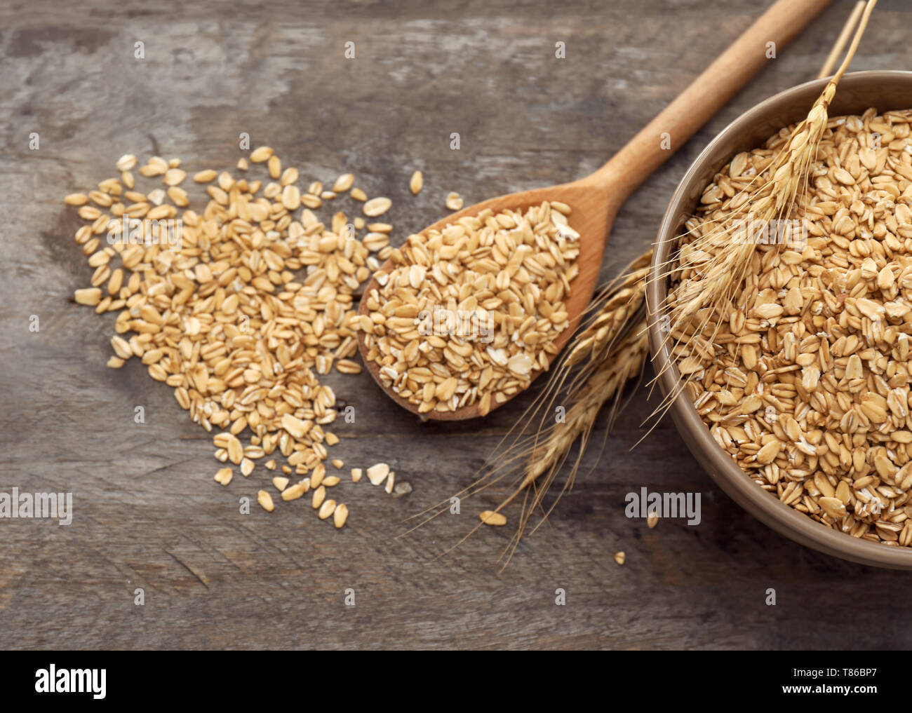 Bowl and spoon with raw oatmeal on wooden background Stock Photo - Alamy