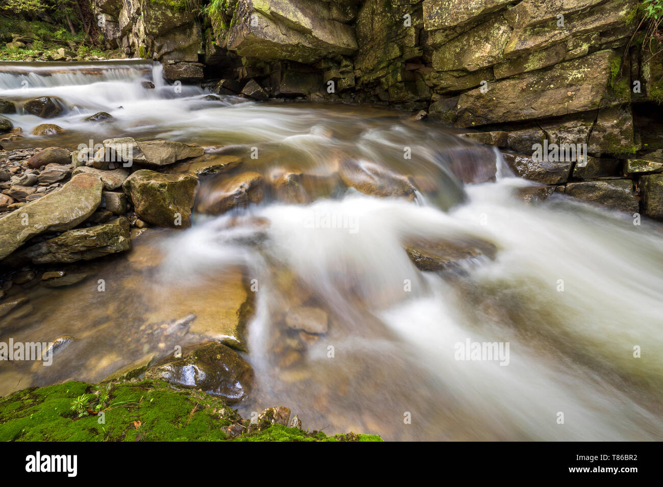 Fast flowing river stream with smooth silky water falling from big ...
