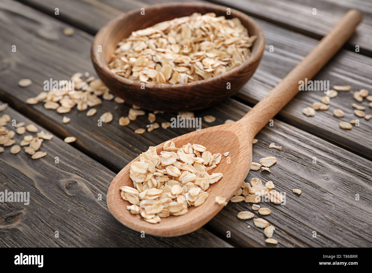 Bowl and spoon with raw oatmeal on wooden background Stock Photo - Alamy