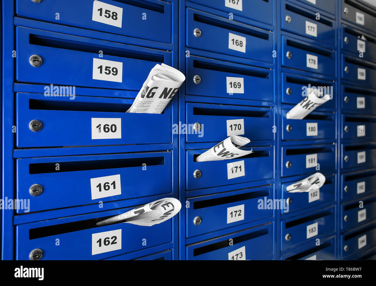 Many mailboxes with newspapers indoors Stock Photo - Alamy