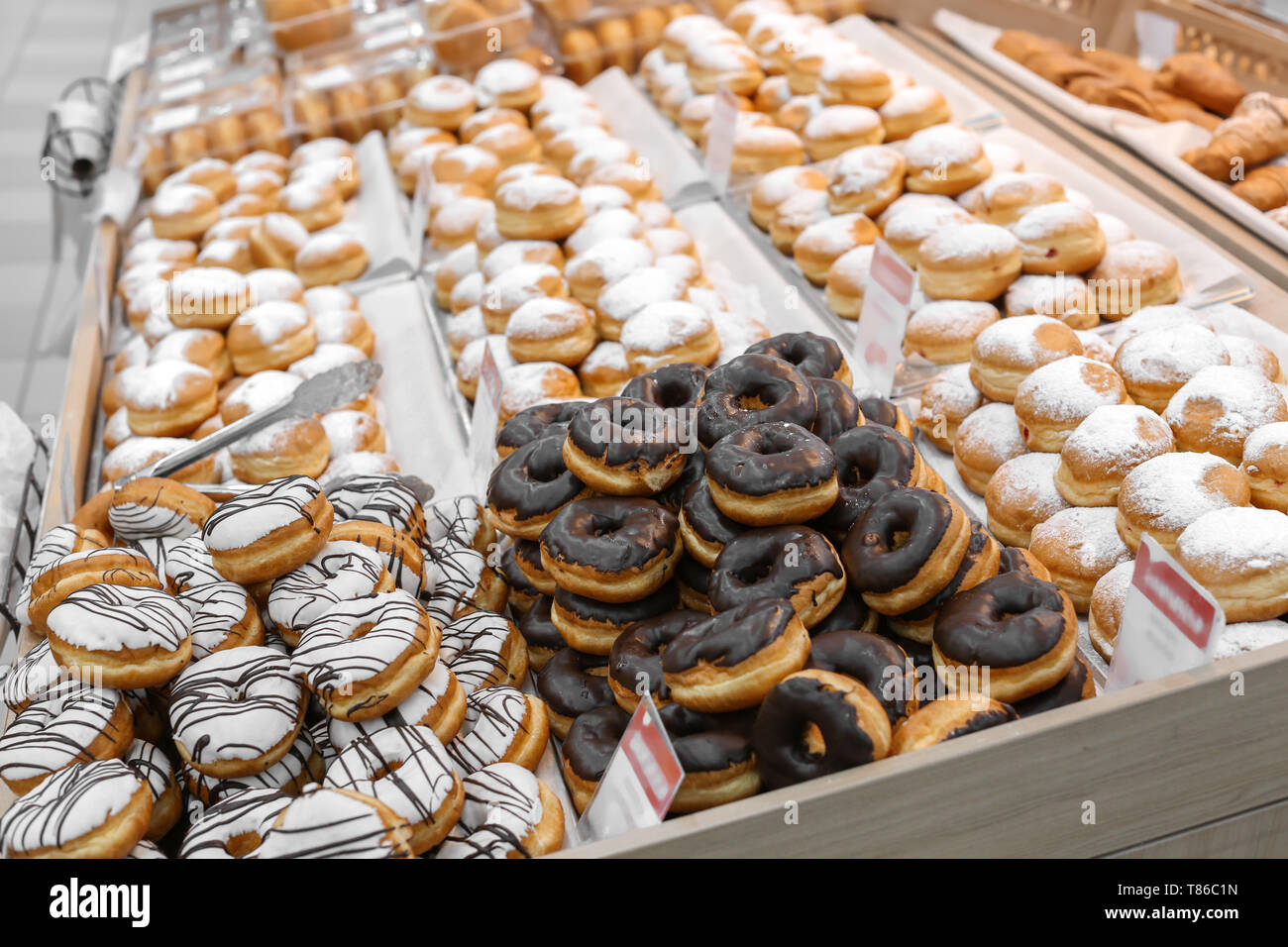 Fresh tasty donuts on display in bakery Stock Photo - Alamy