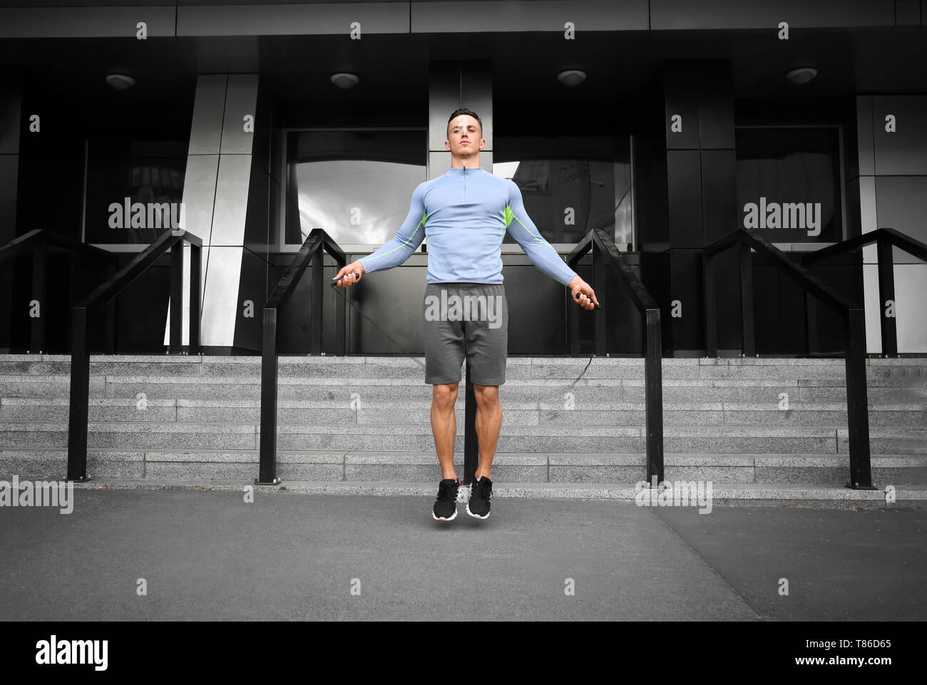 Sporty young man jumping rope outdoors Stock Photo - Alamy