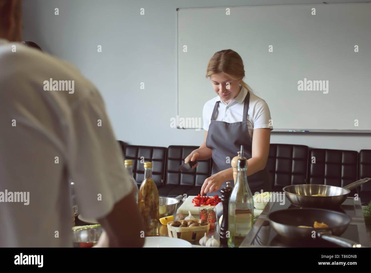 Young woman cooking in restaurant kitchen during cooking classes Stock ...