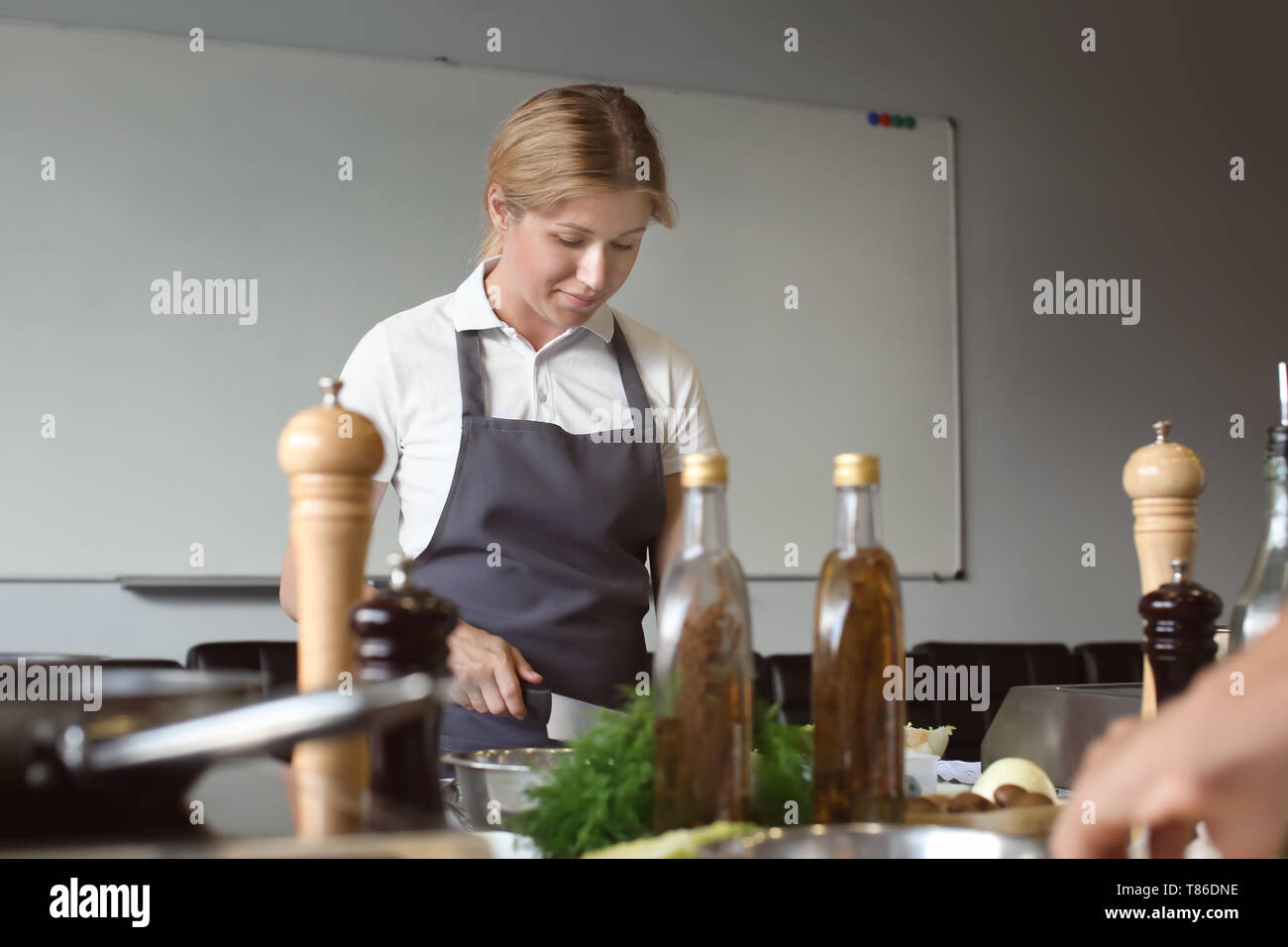 Young woman cooking in restaurant kitchen during cooking classes Stock ...