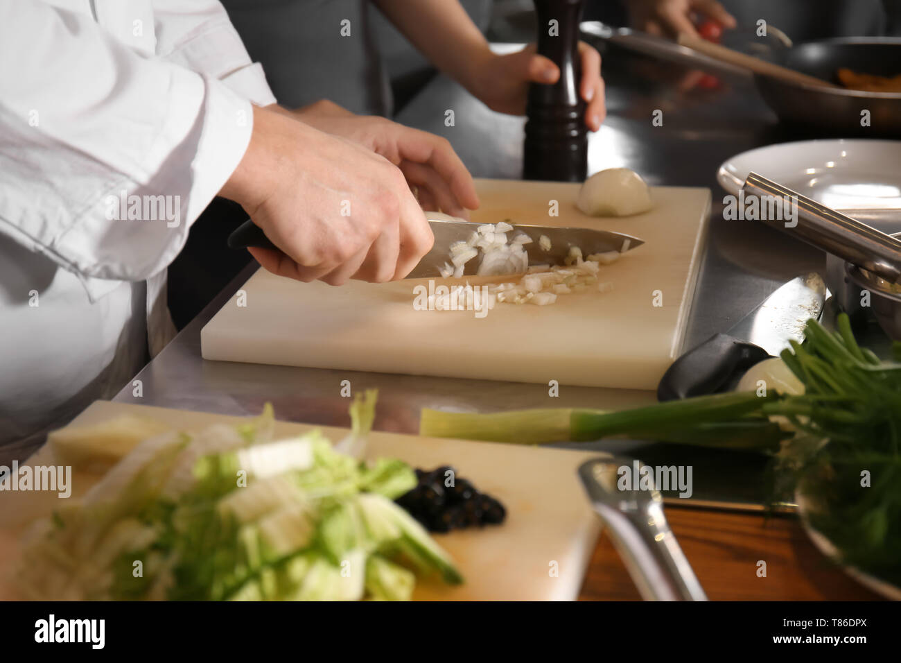 Male chef cutting vegetables during cooking classes Stock Photo - Alamy