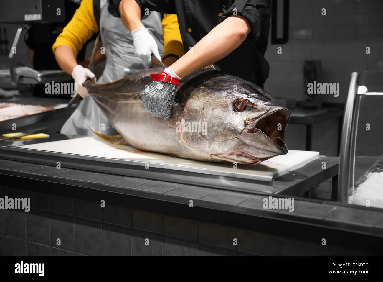 Man working with fresh tuna at table in fish market Stock Photo - Alamy