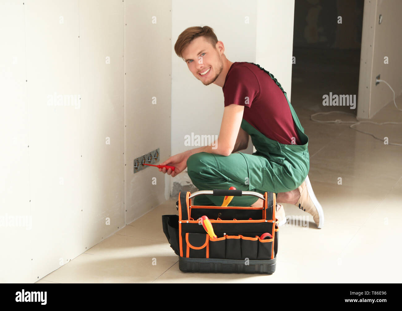 Male electrician repairing socket in flat Stock Photo - Alamy