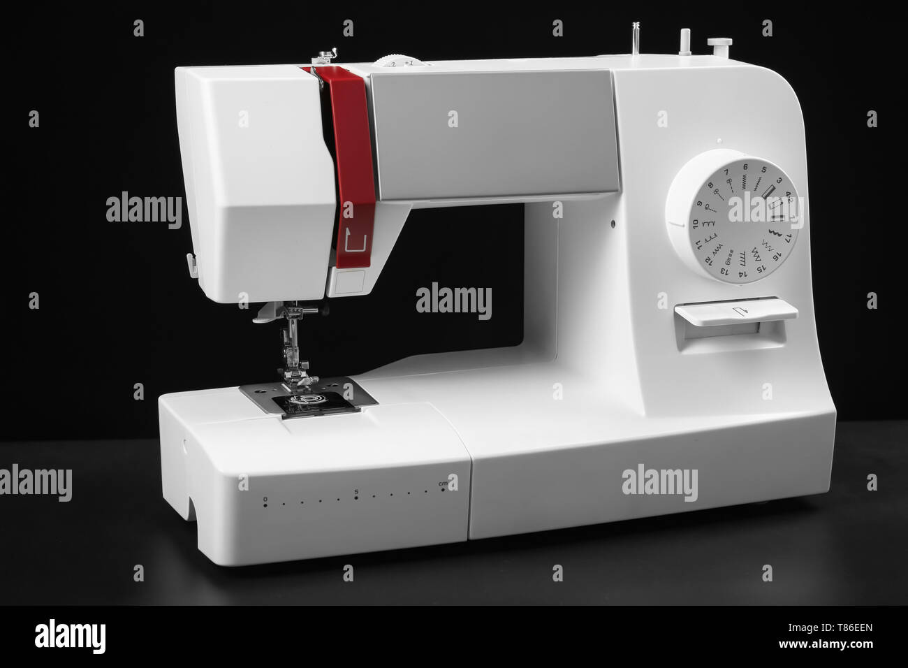 Sewing machine on dark background Stock Photo - Alamy