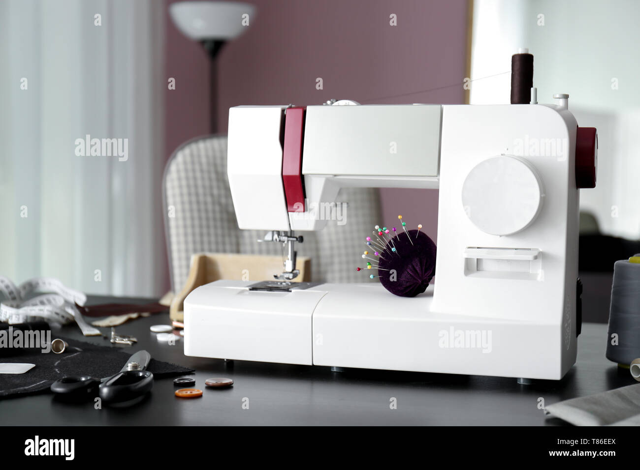 Sewing machine with accessories on table in tailor's workshop Stock ...