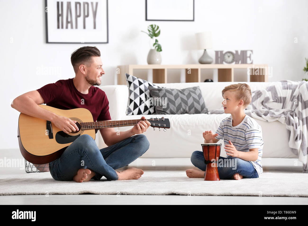 Little boy and his dad with music instruments playing at home Stock ...