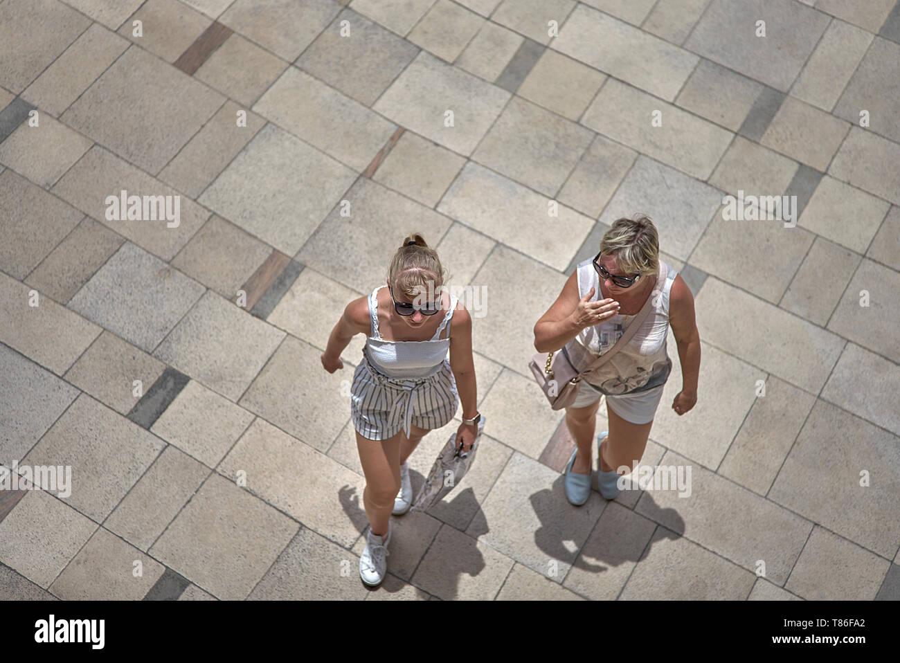 People from above . Overhead view of two women walking together on a ...