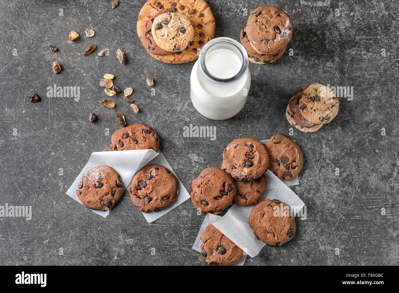 Delicious chocolate chip cookies and milk in bottle on dark background ...