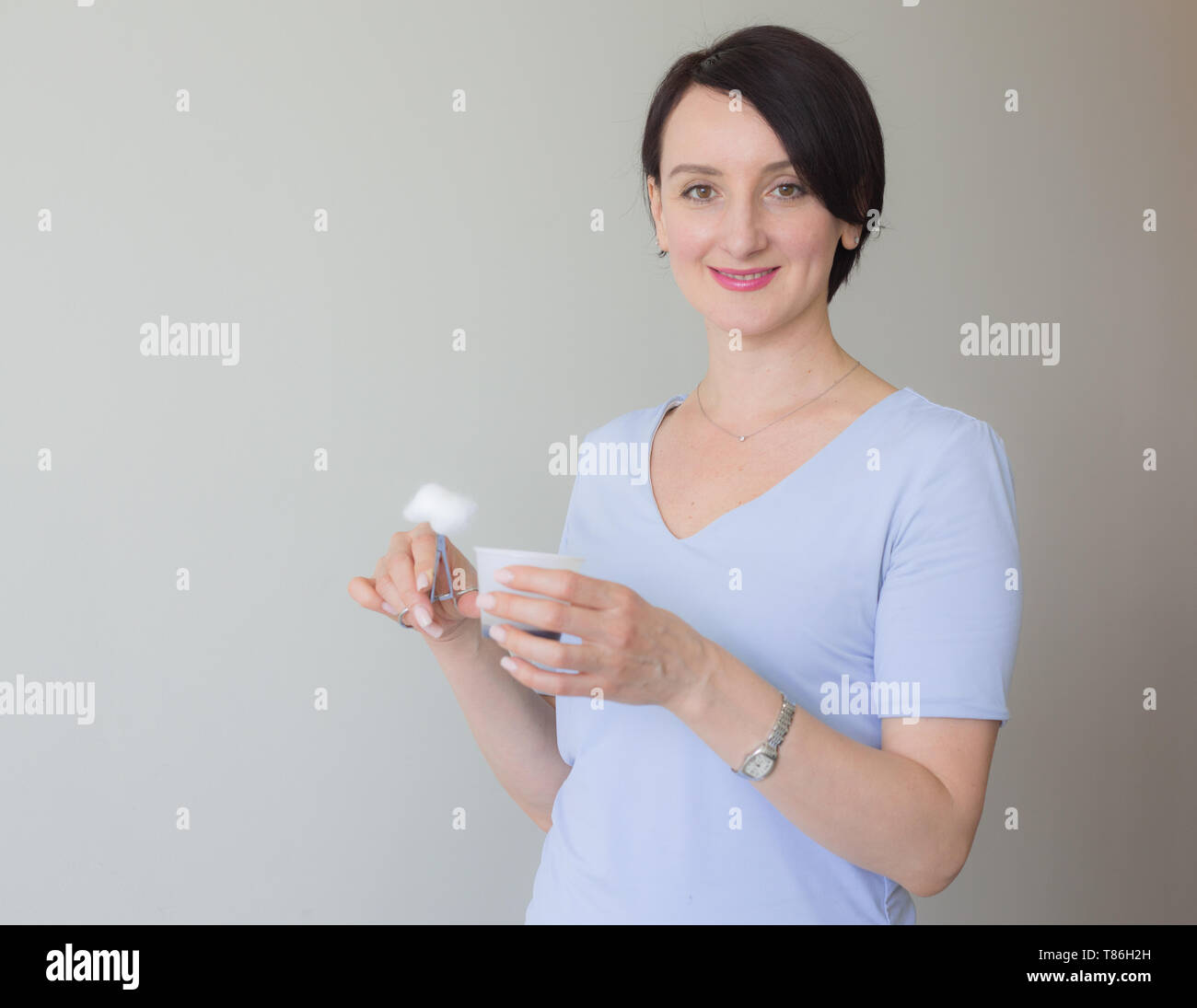 Female doctor holding medical clamp cotton ball Stock Photo - Alamy