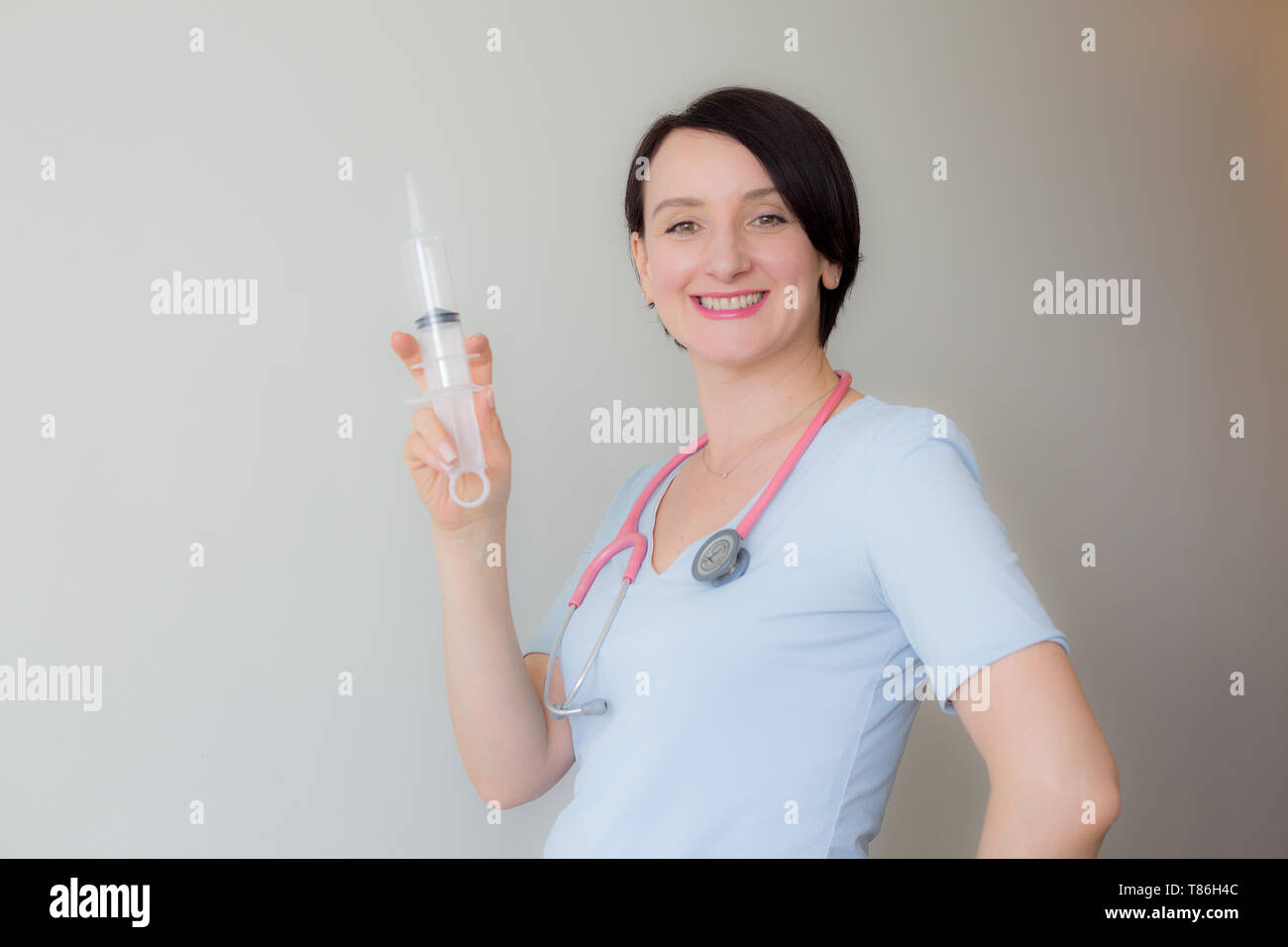 Beautiful smiling nurse holding syringe isolated portrait Stock Photo ...