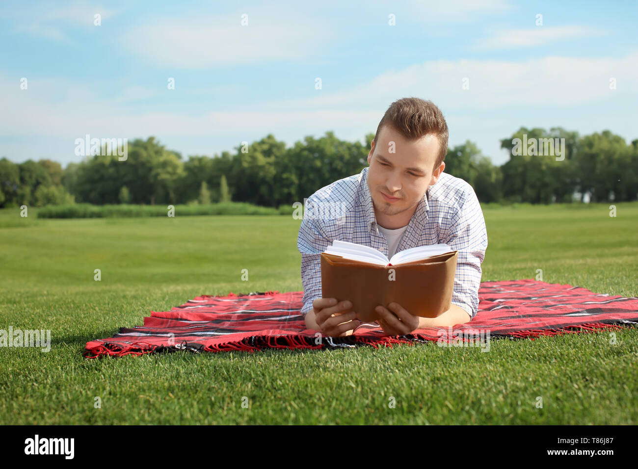 Man lying on lawn reading hi-res stock photography and images - Alamy