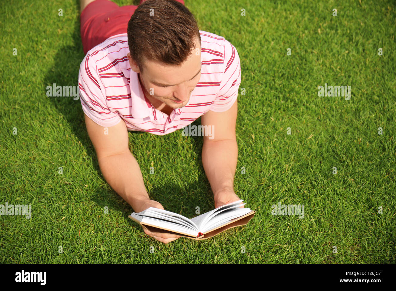 Man lying on lawn reading hi-res stock photography and images - Alamy