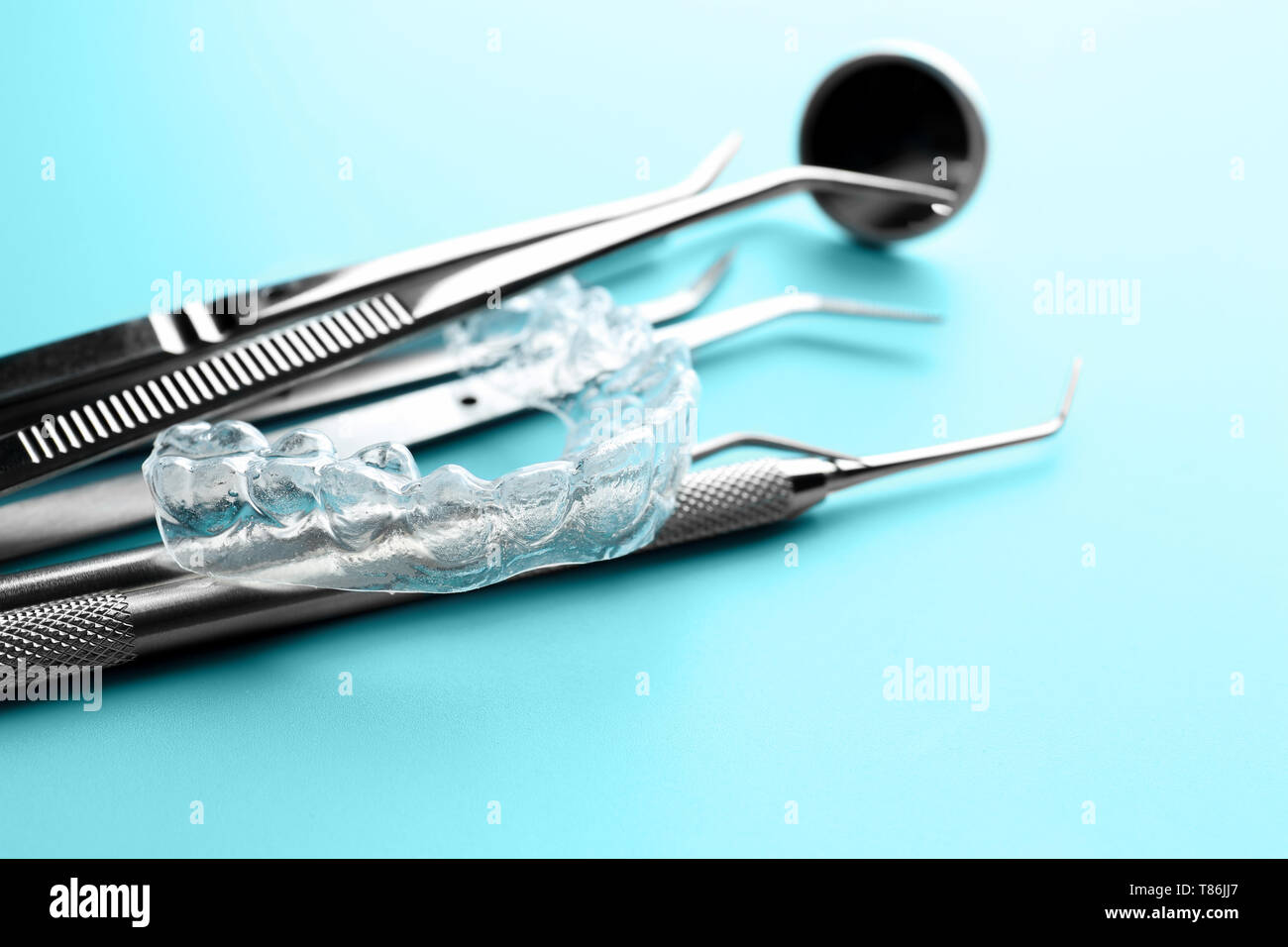 Dental instruments and occlusal splint on color background, closeup ...