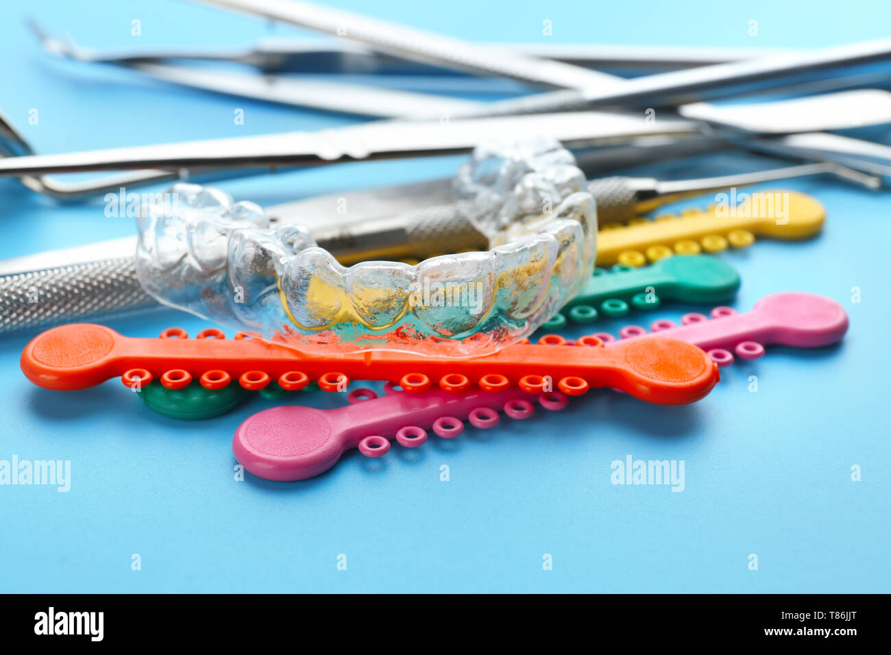 Dental instruments and occlusal splint on color background, closeup ...