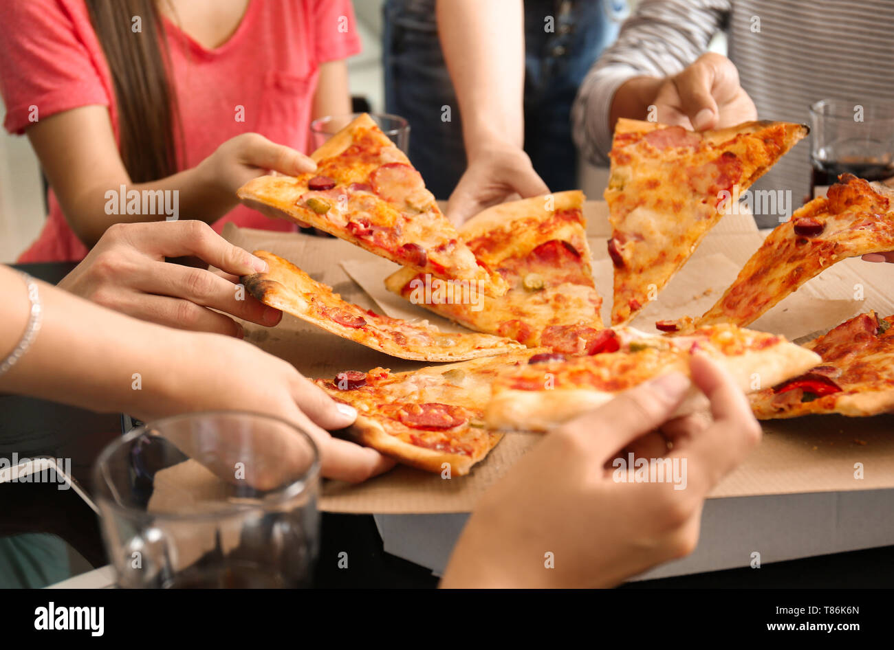 Young people taking slices of hot tasty pizza from cardboard box Stock ...