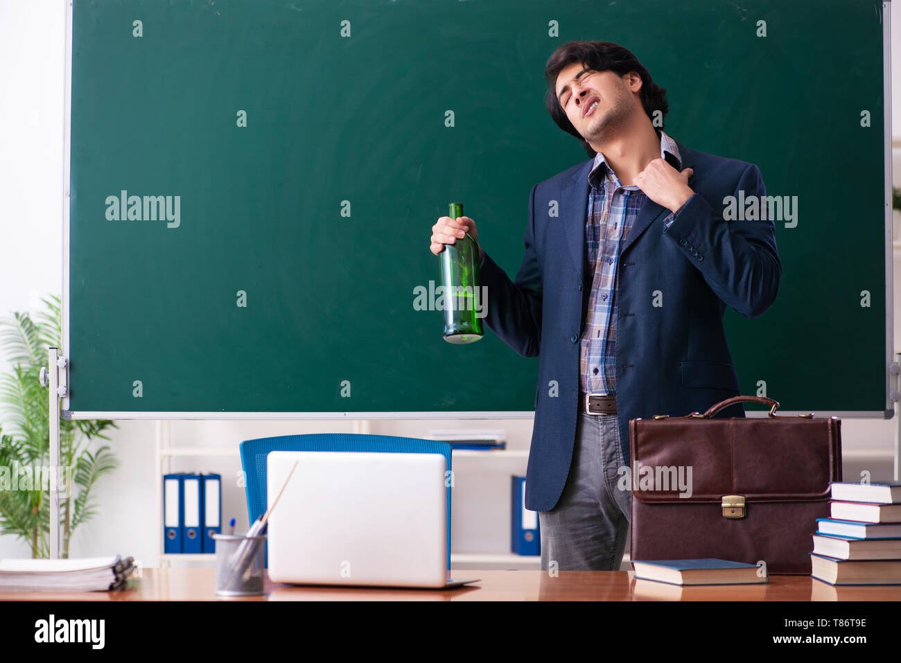 Male teacher drinking in the classroom Stock Photo - Alamy
