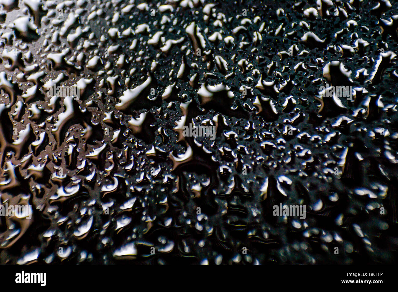 oil and water drops on black glass surface abstract background Stock ...