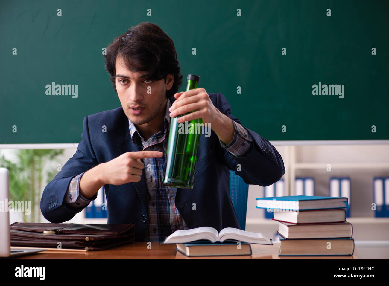 Male teacher drinking in the classroom Stock Photo - Alamy