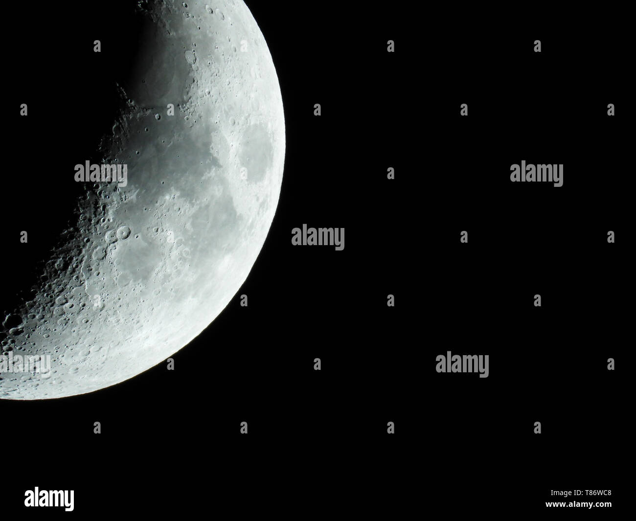 a very sharp close-up of the rising crescent moon in the night sky ...