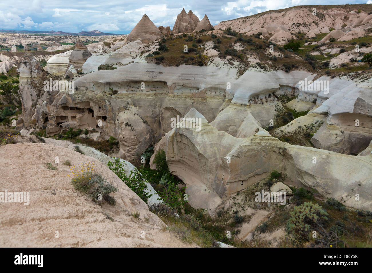 Red and white sandstone cliffs, ancient caves in a mountain landscape ...