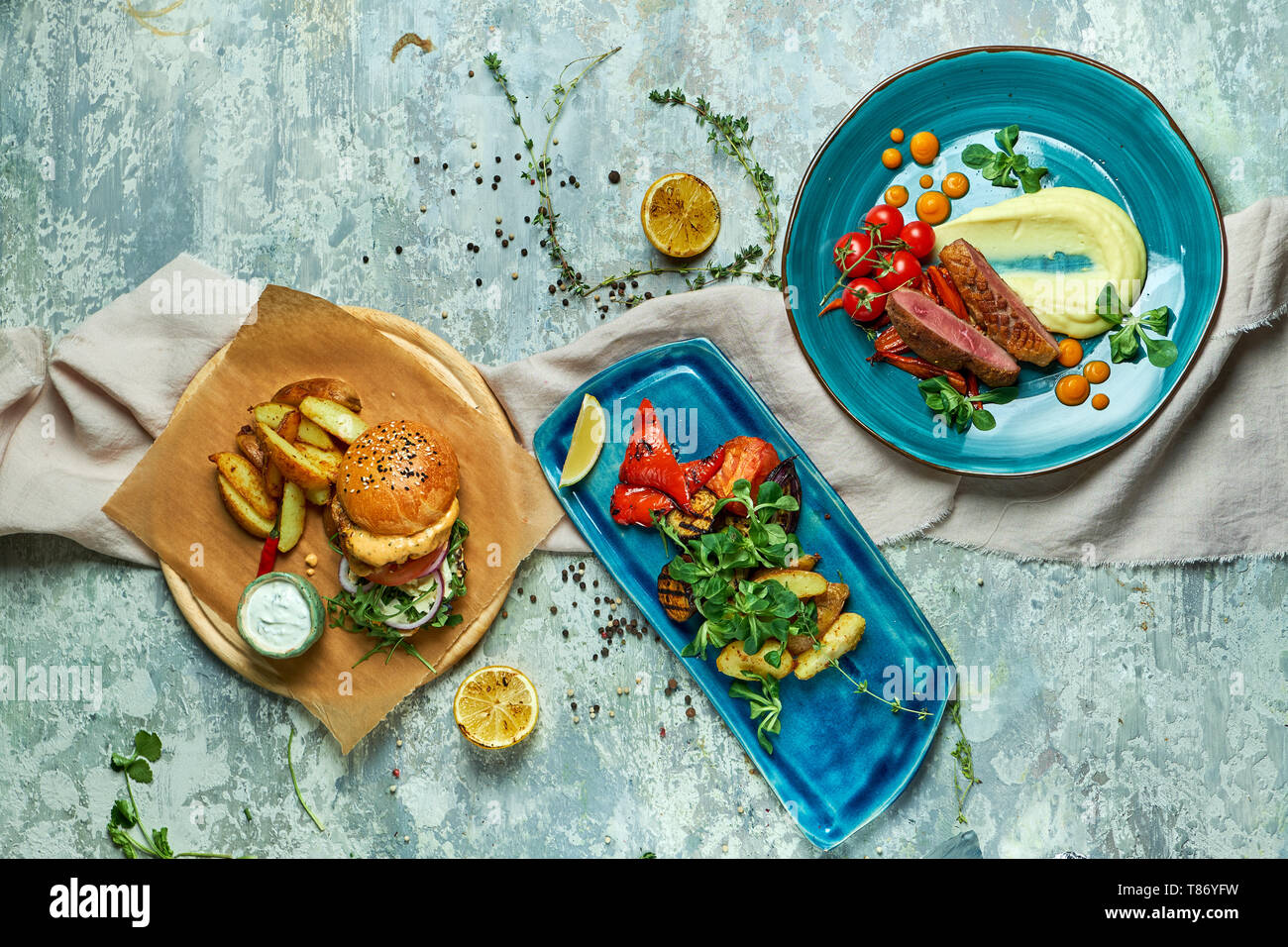 Three dishes with meat burger with grilled vegetables view svrhu on a ...