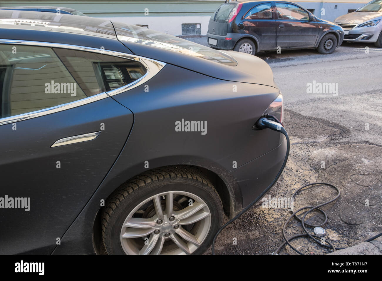 Electric modern car charging with cable power supply plugged on wayside ...