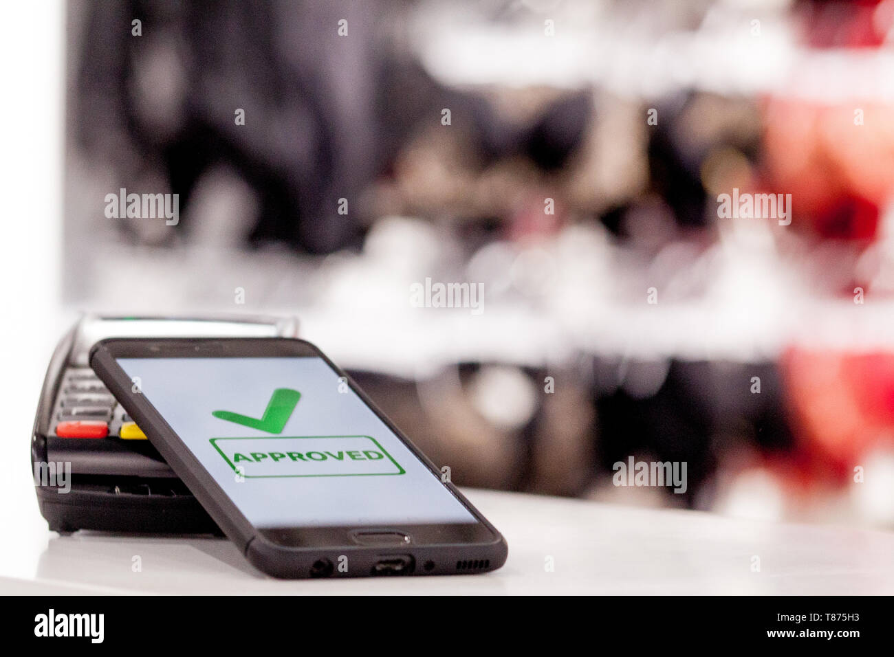 POS terminal, Payment Machine with mobile phone on store background ...