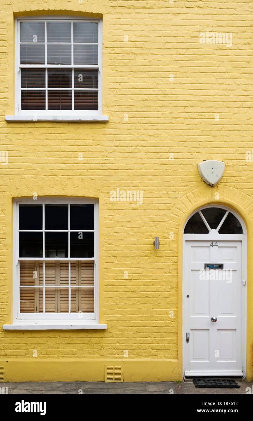 Colourful yellow painted house in Godfrey street, Chelsea, London ...