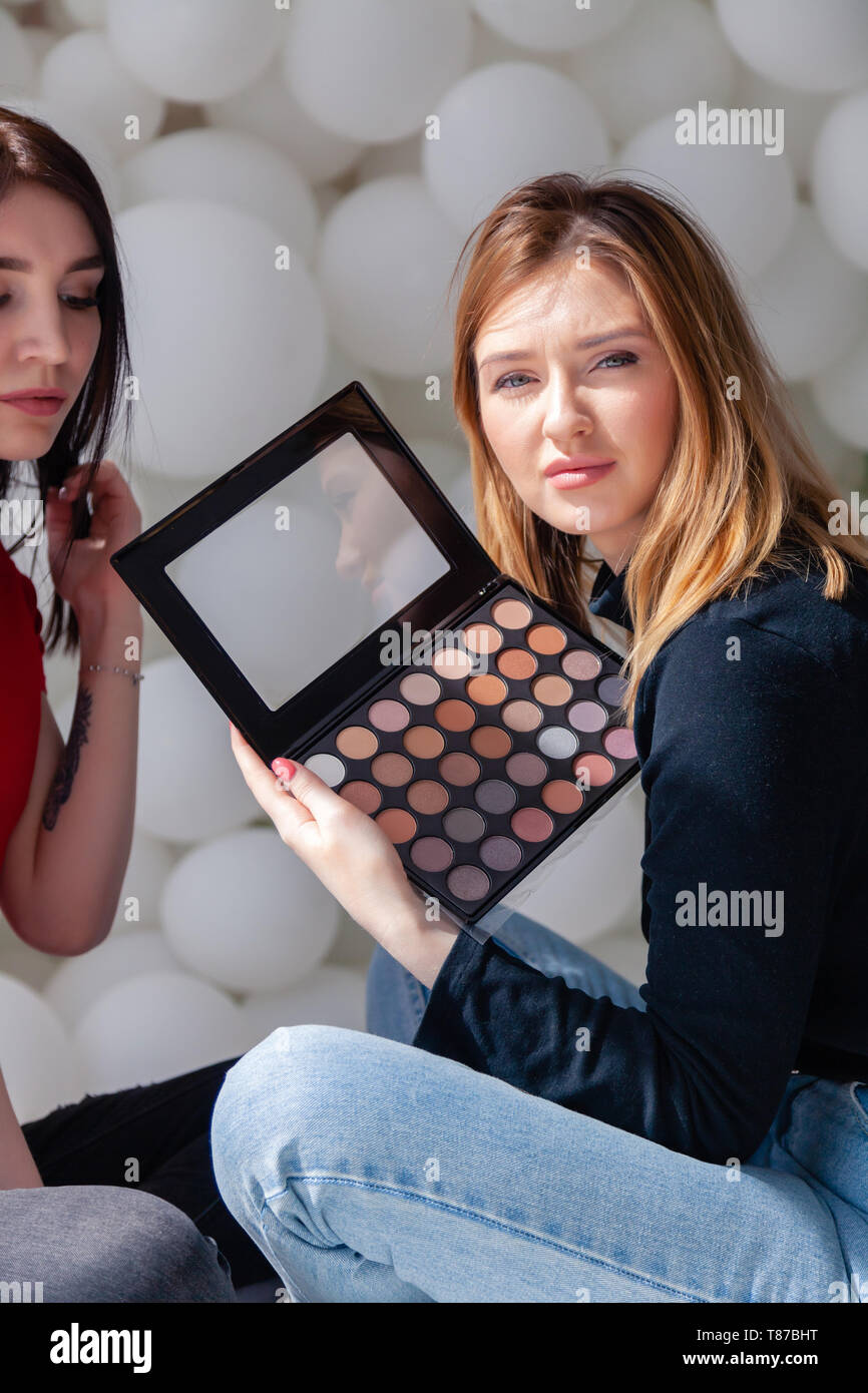 Makeup artist doing professional make up, applies eye shadows to ...