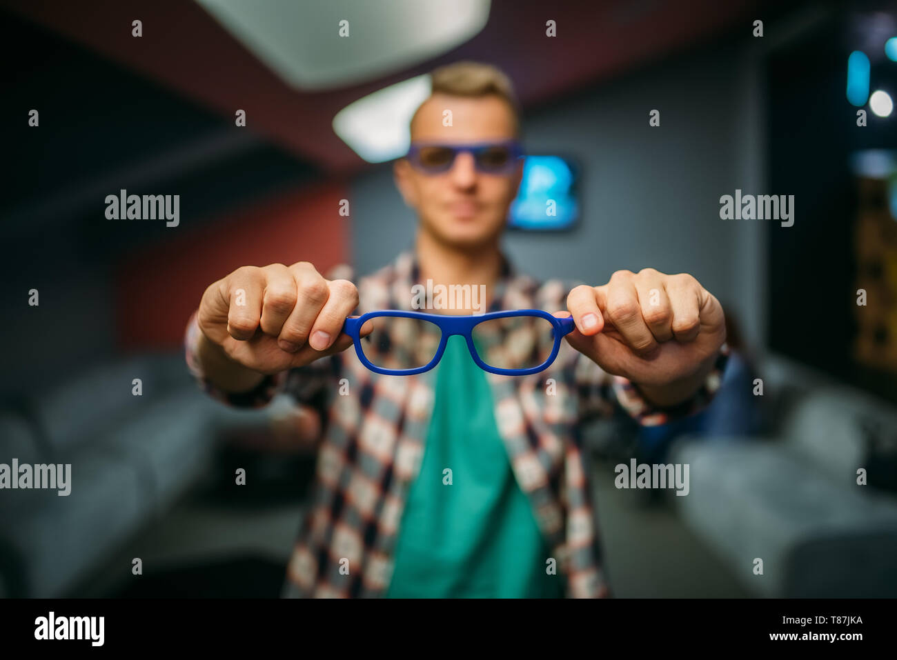 Male spectator shows 3d glasses in cinema hall Stock Photo - Alamy