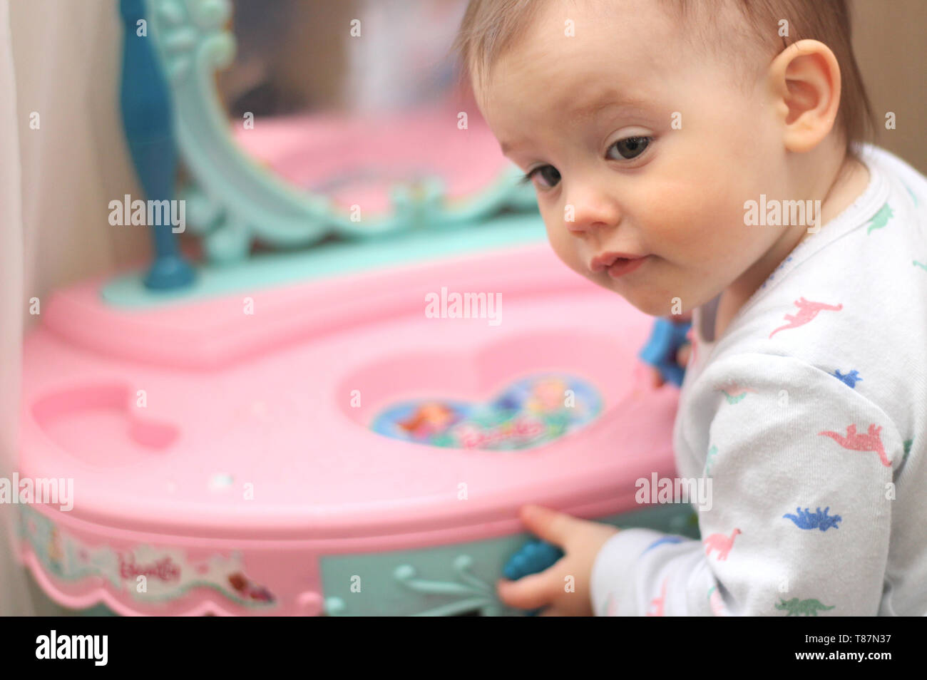 a small child plays in front of a toy mirror in the nursery Stock Photo ...
