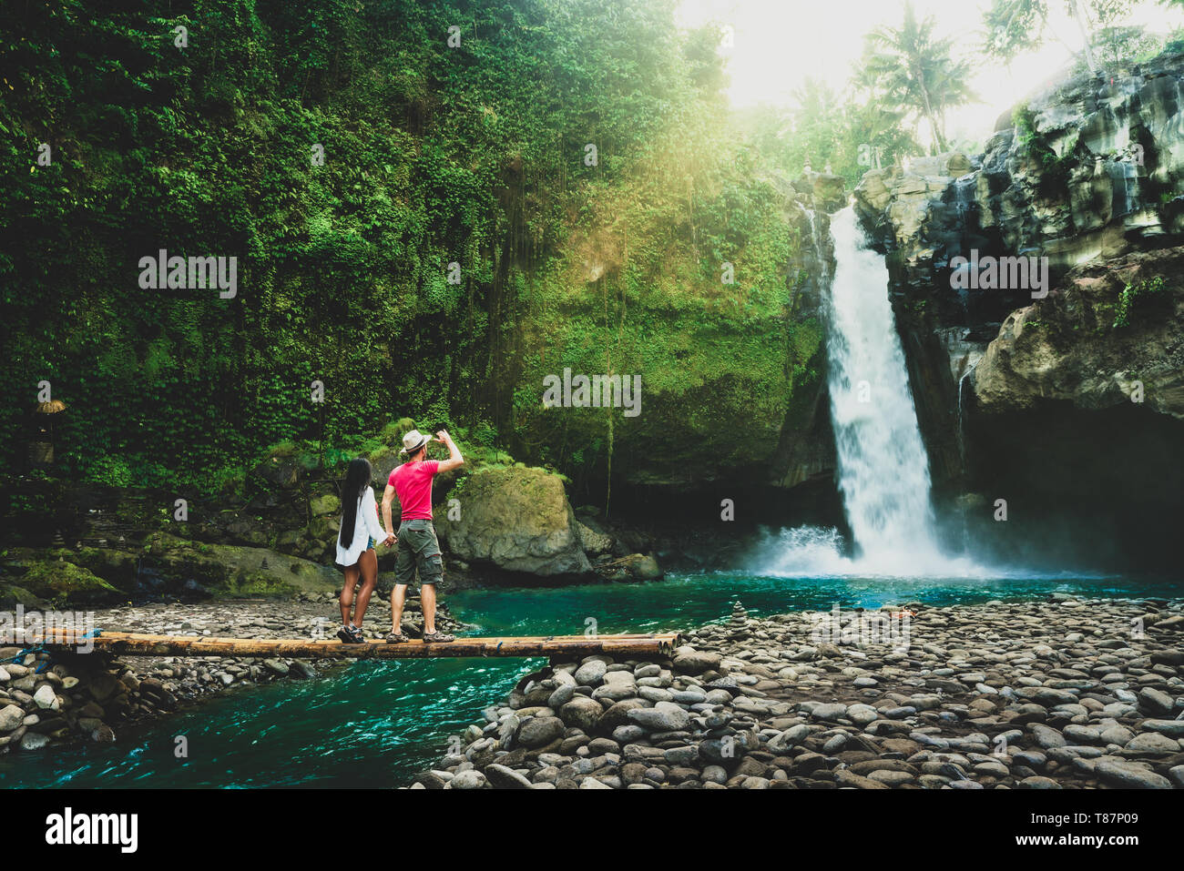 Romantic couple hugging in river under tropical waterfall Stock Photo ...