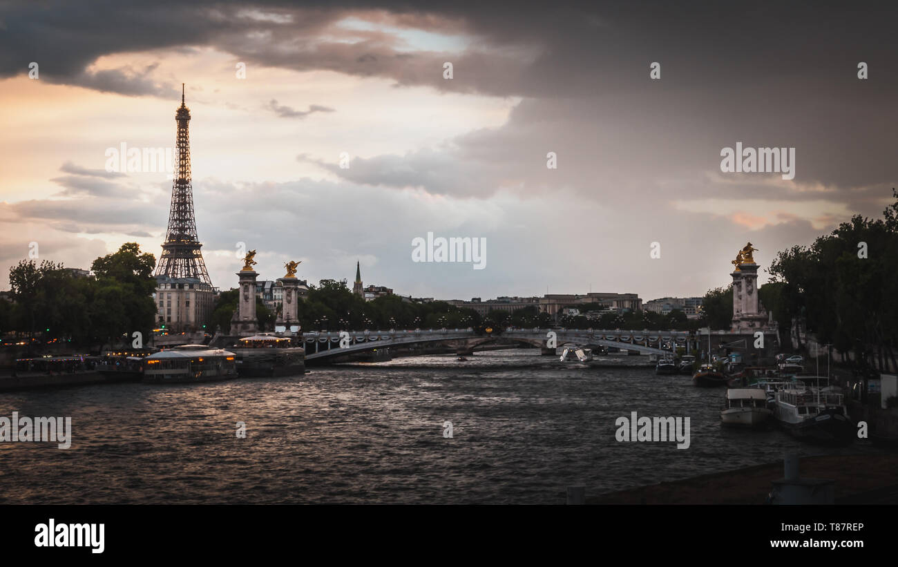 The Seine River and the Eiffel Tower under a dark sunset in Paris Stock ...
