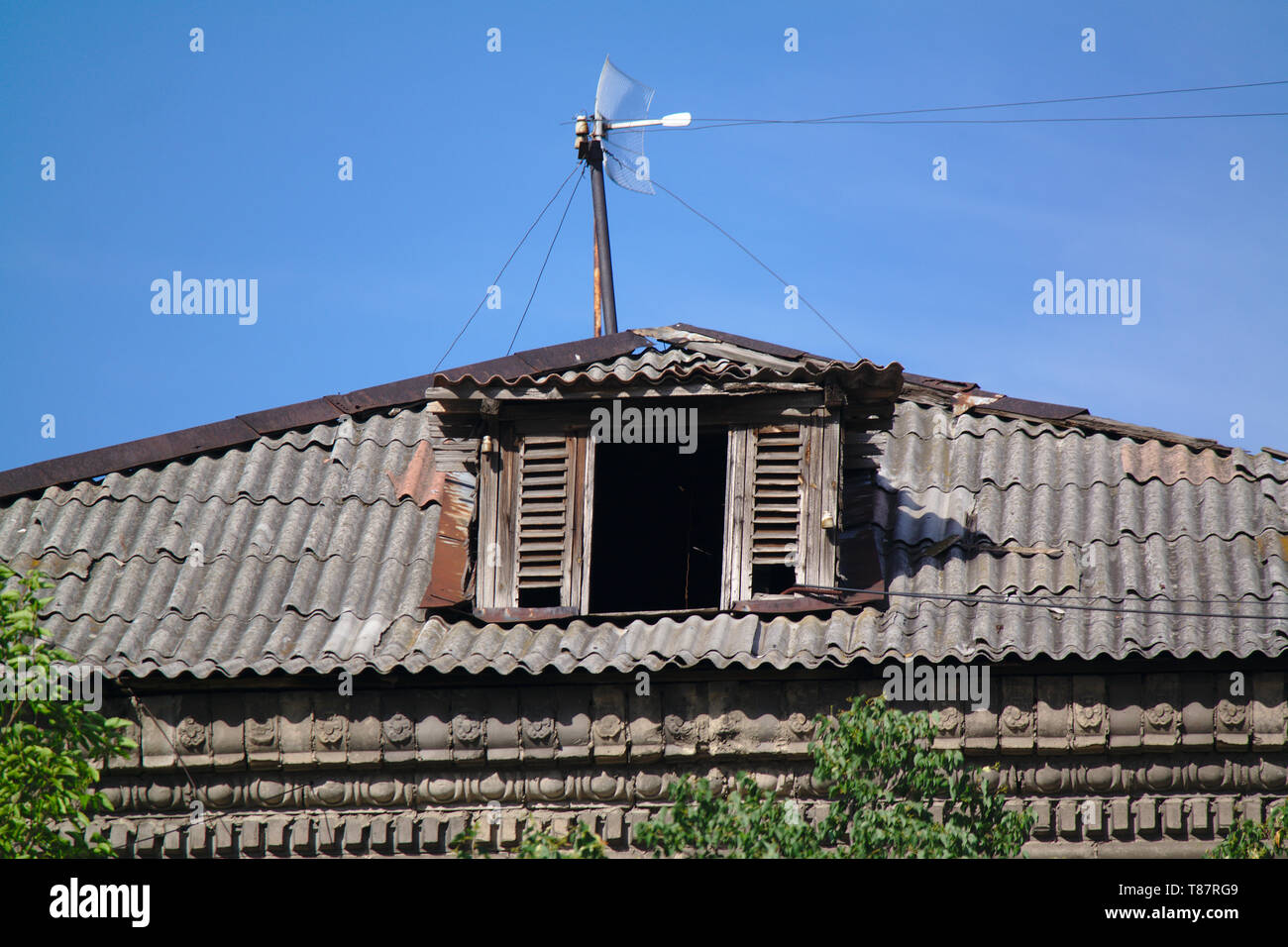 old broken attic window of a house with a rooftop antenna Stock Photo ...
