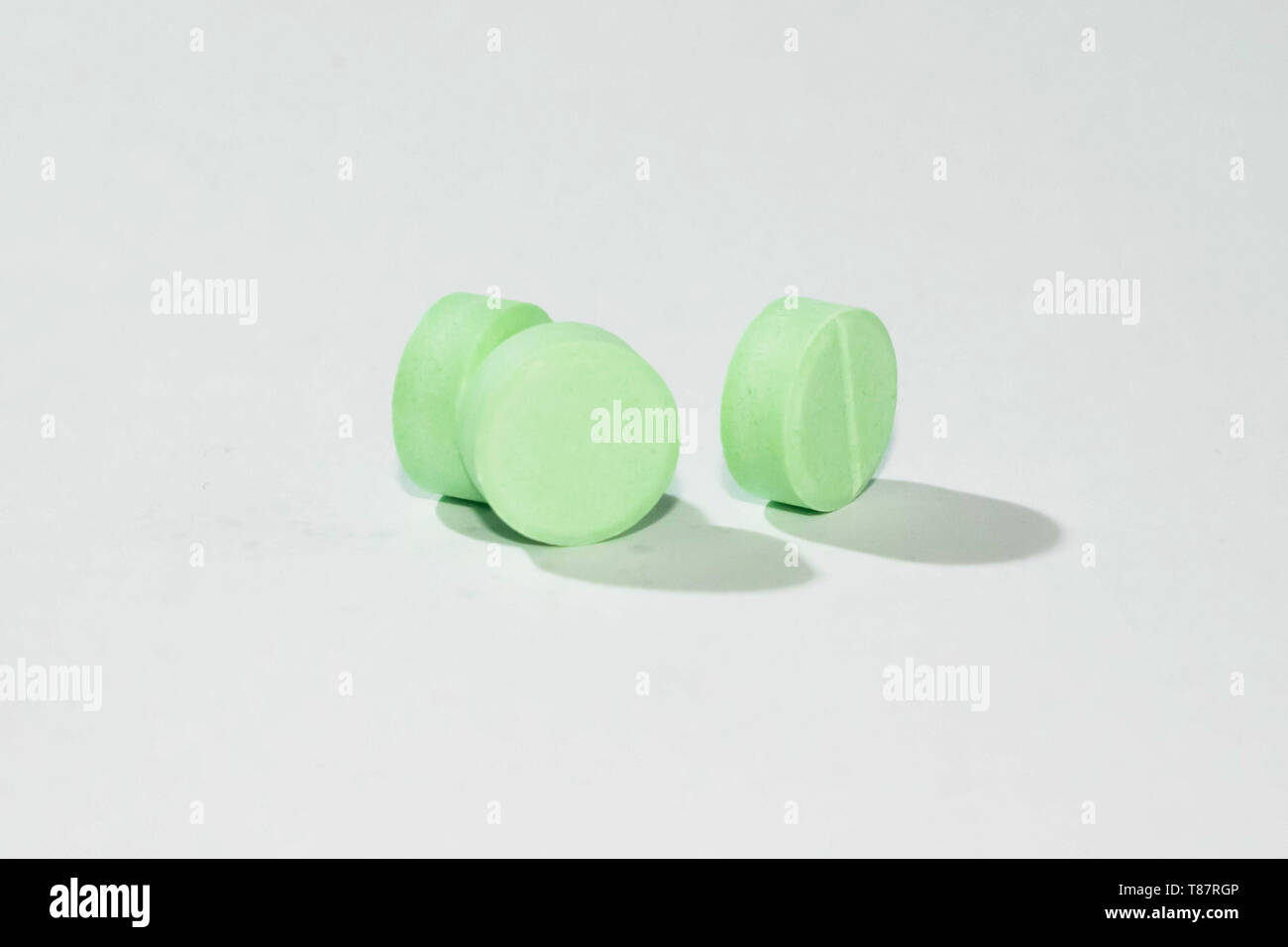 Green round pills standing and isolated on white background Stock Photo ...