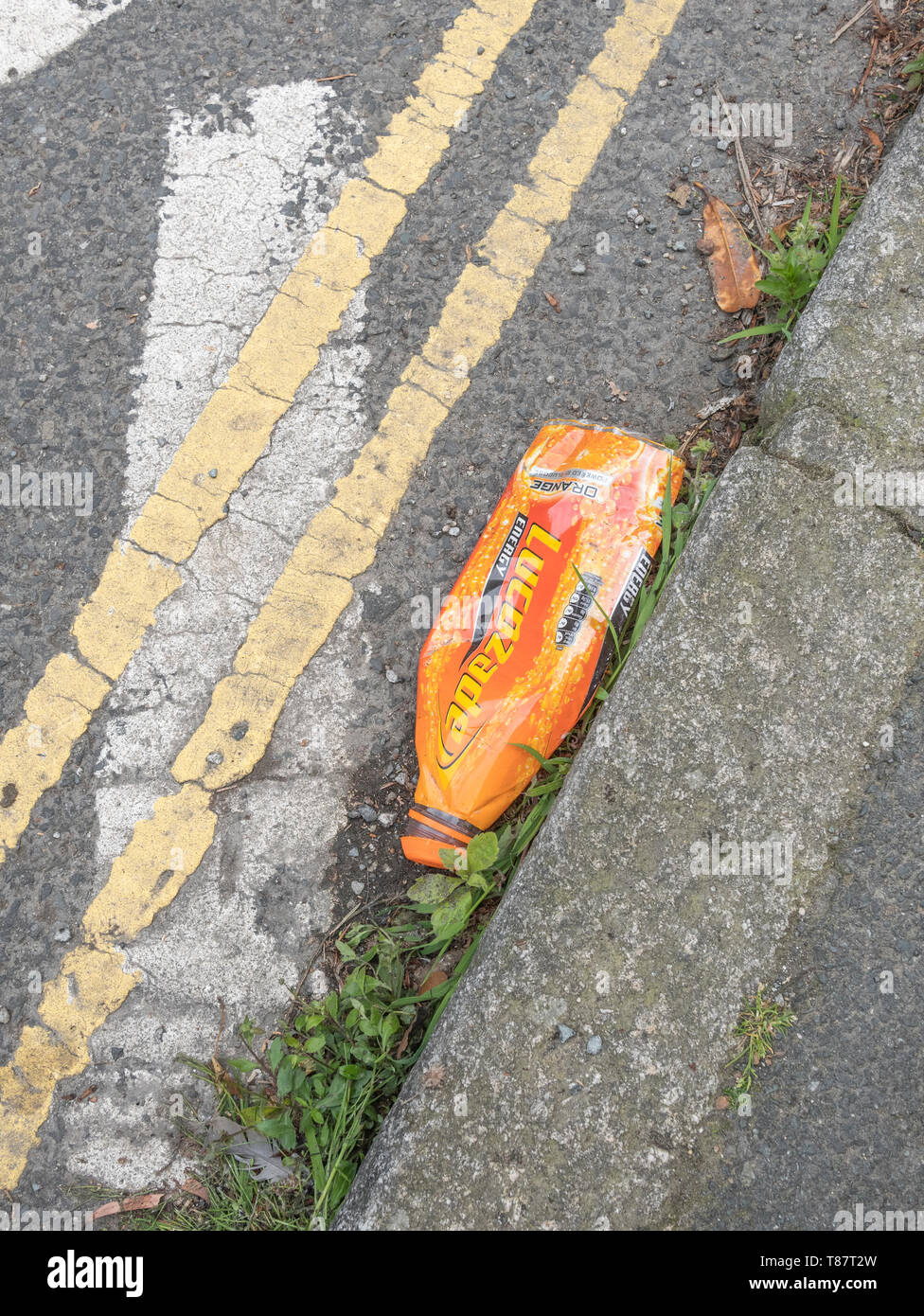 Empty plastic bottle lying in street gutter. Plastic waste / war on ...