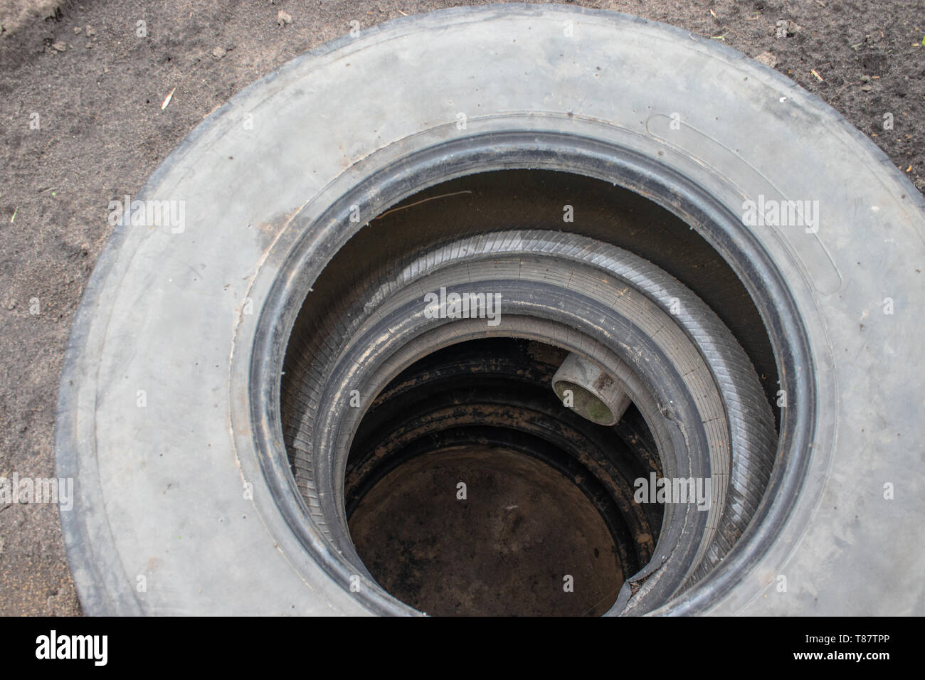 Sewer pit with car tires. Sewer system Stock Photo - Alamy