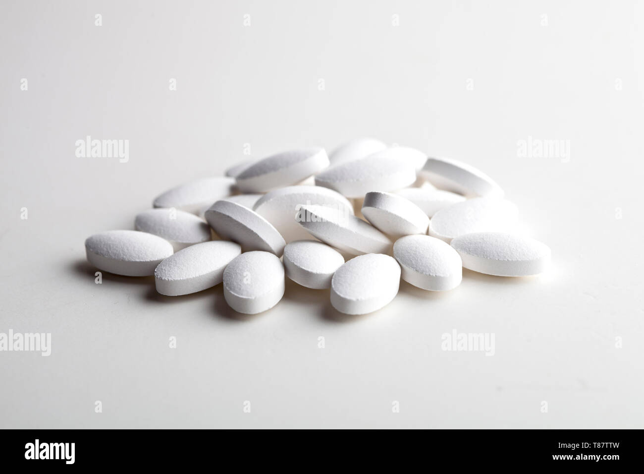 Pile of white drug pills laying on white background. Medical concept ...