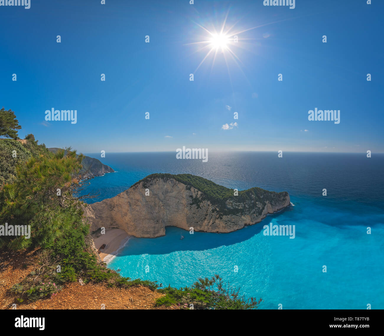 View of the sun shining over cliffs in Shipwreck Cove in summer on ...