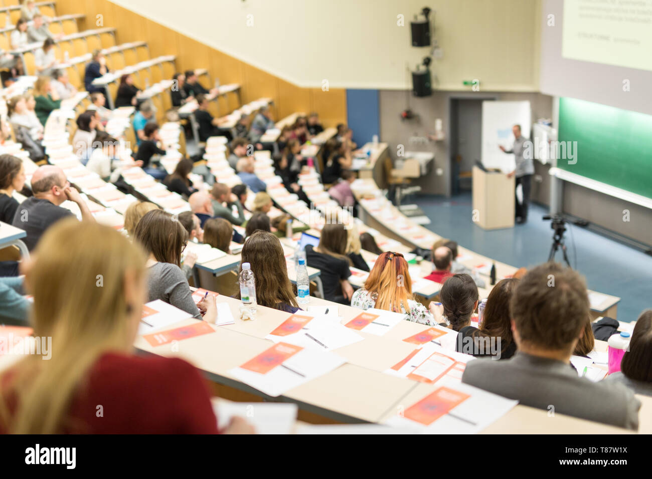 Audience in the lecture hall. Female student making notes Stock Photo ...