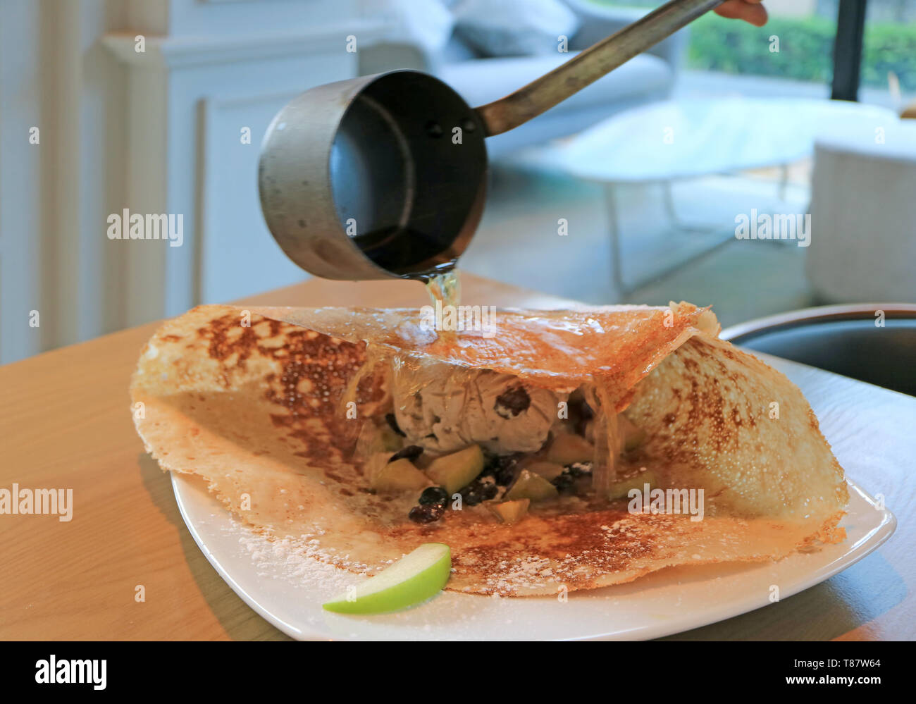 Presentation of Apple Raisin Crepe Flambe on Guest Table Stock Photo ...