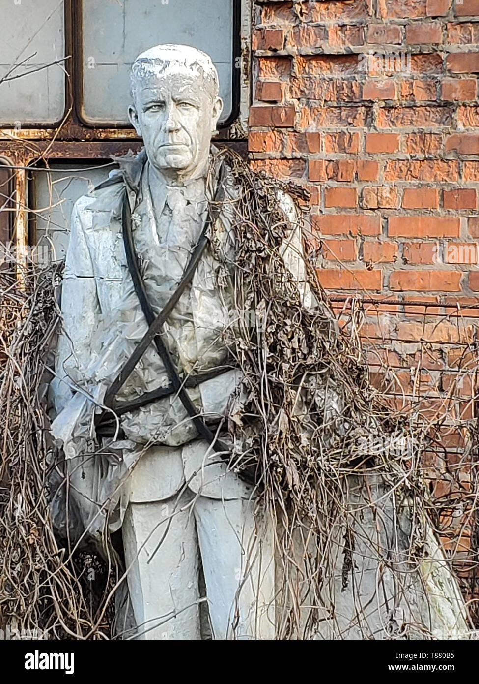 Old abandoned sculptures in a neglected park entwined with plants ...