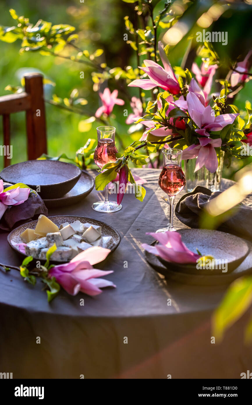 Beautiful table setting in garden on sunset light. Table decorated with ...